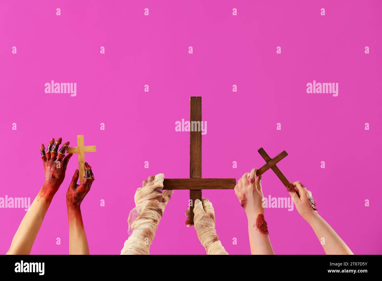 Zombie and mummy hands with wooden crosses on pink background ...