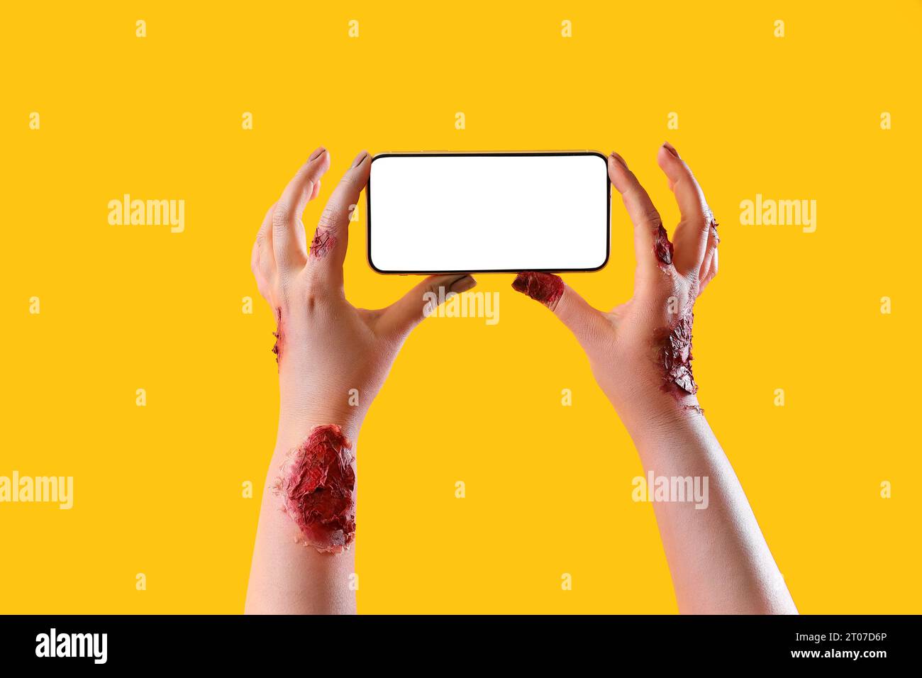 Zombie hands holding mobile phone with blank screen on yellow ...