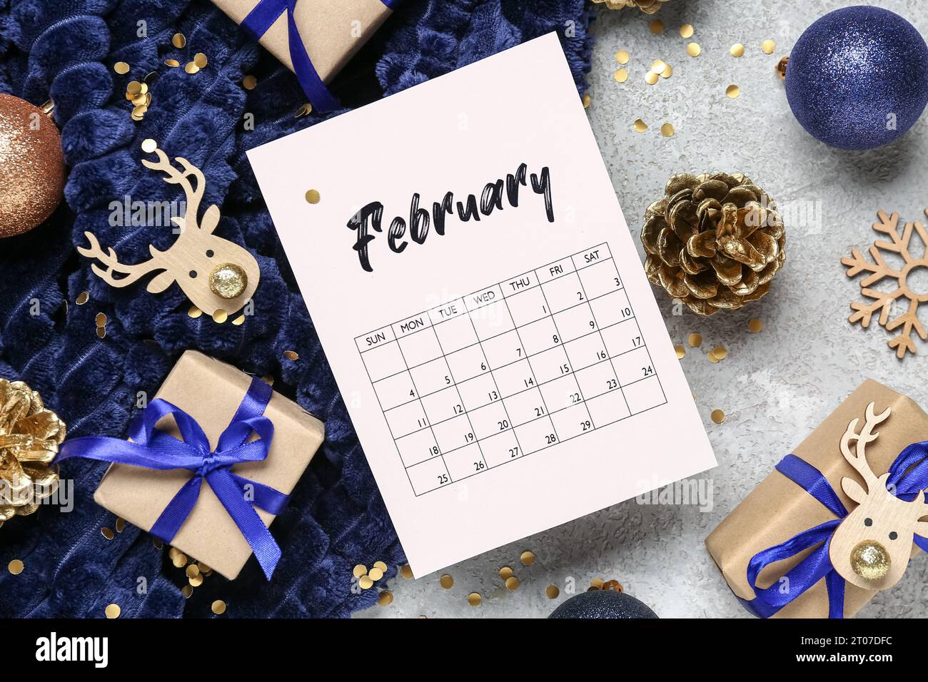 Paper calendar for February, gift boxes and Christmas decorations on ...