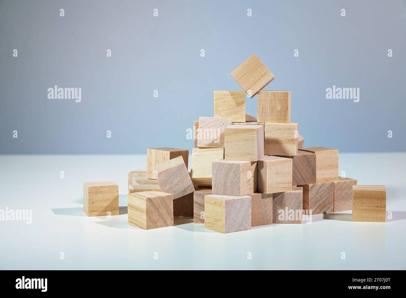 Teamwork with a broad base is the way up, heap of wooden cubes holding ...