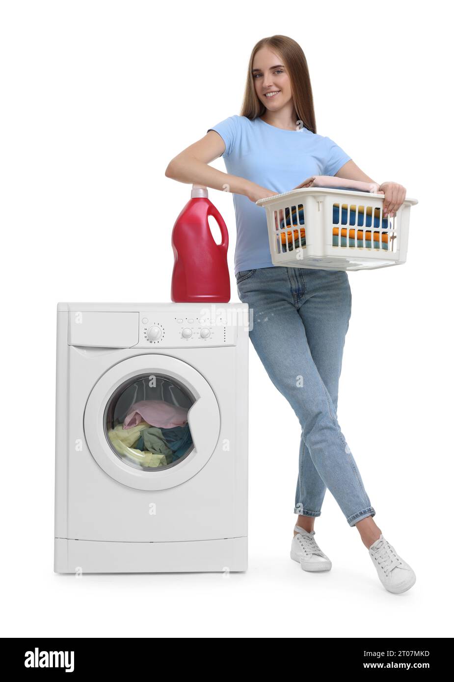 Beautiful young woman with laundry basket and detergent near washing machine on white background ...