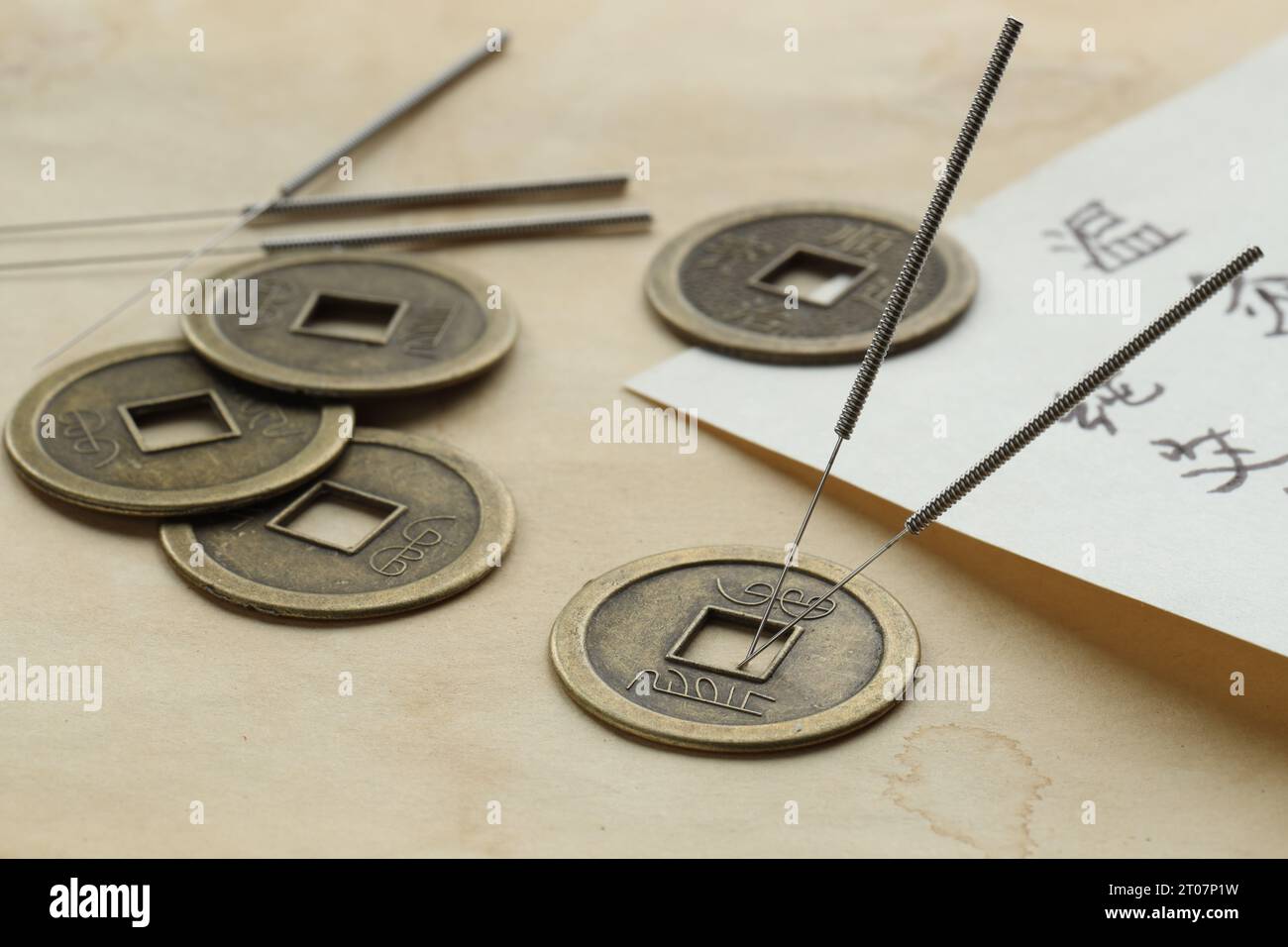 Acupuncture needles, Chinese coins and sheet with characters on paper ...