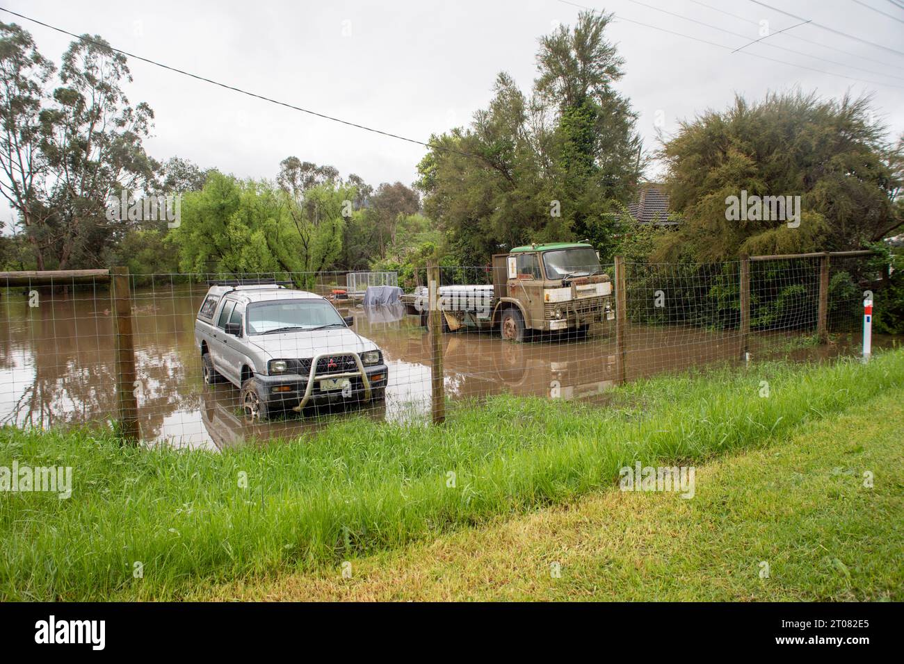 Flood waters rising in a yard with a car and a truck. Launching Place ...
