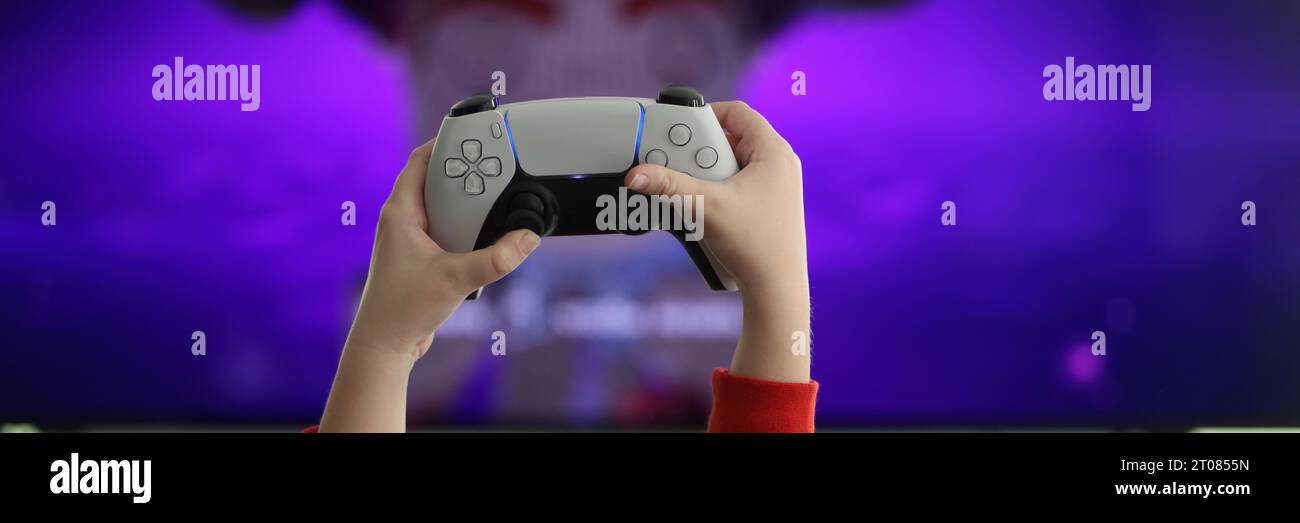 Hands of little girl holding game console against screen Stock Photo ...