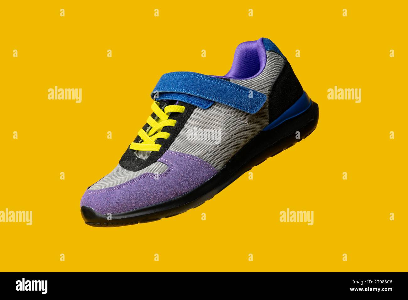 Violet-blue female sneakers on yellow studio background Stock Photo - Alamy