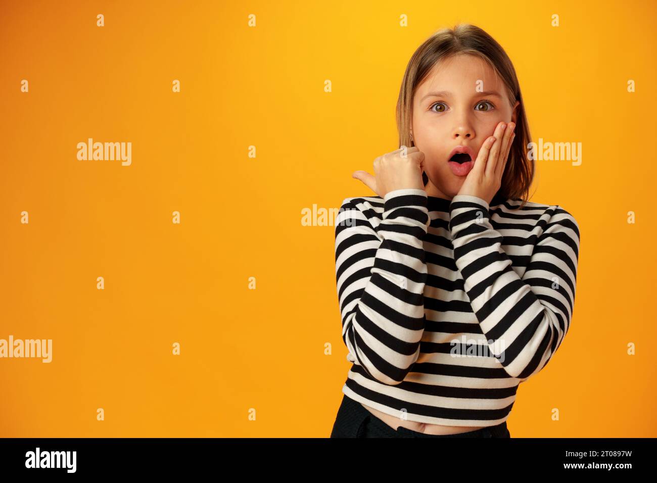 Upset disturbed teen girl on yellow background in studio Stock Photo ...