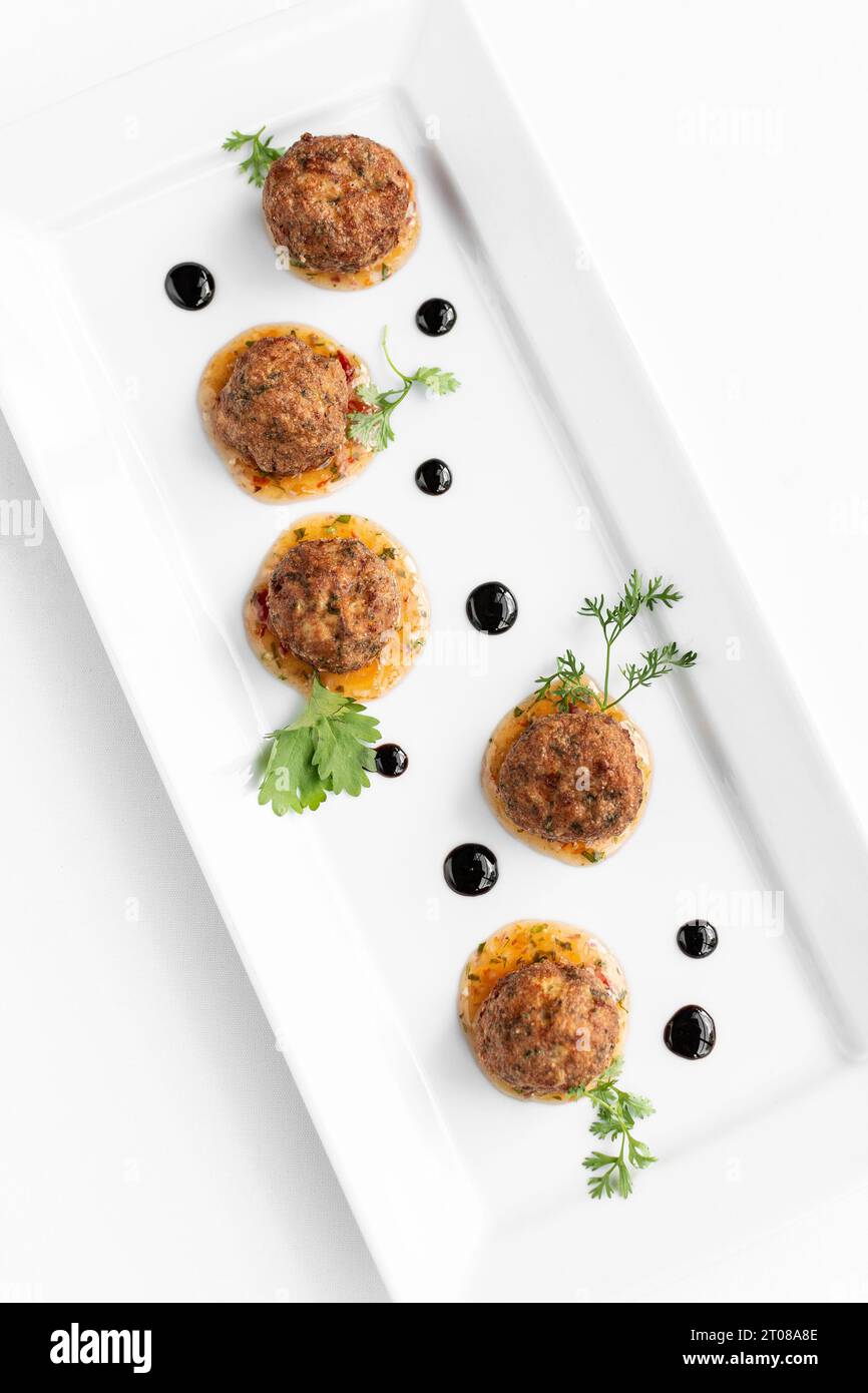 thai fish cake balls in gourmet contemporary restaurant on white plate ...