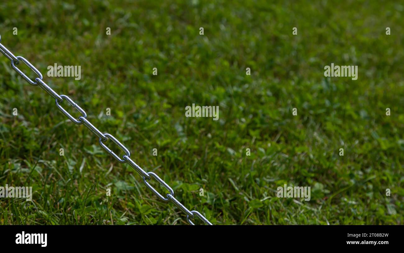 steel non-rusty chain on grass background, frame Stock Photo - Alamy