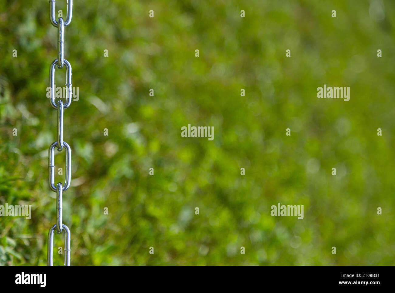 steel non-rusty chain on grass background, frame Stock Photo - Alamy