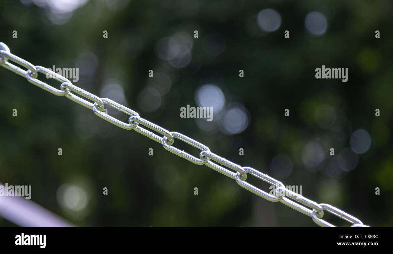 steel non-rusty chain on grass background, frame Stock Photo - Alamy