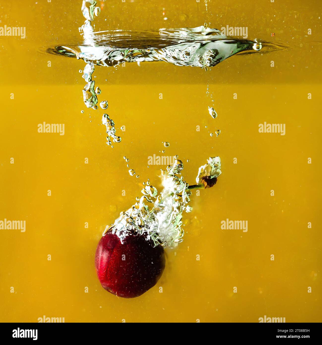 ripe cherries fall into the water raising splashes and air bubbles ...