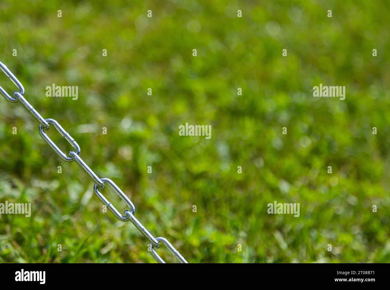 steel non-rusty chain on grass background, frame Stock Photo - Alamy