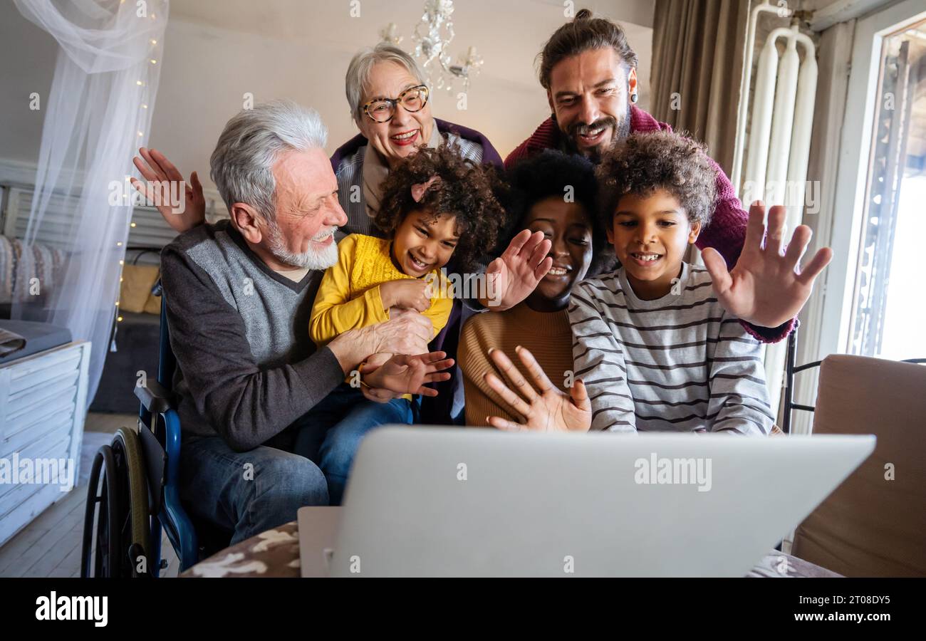 Extended multiethnic family together at home during video call. People ...