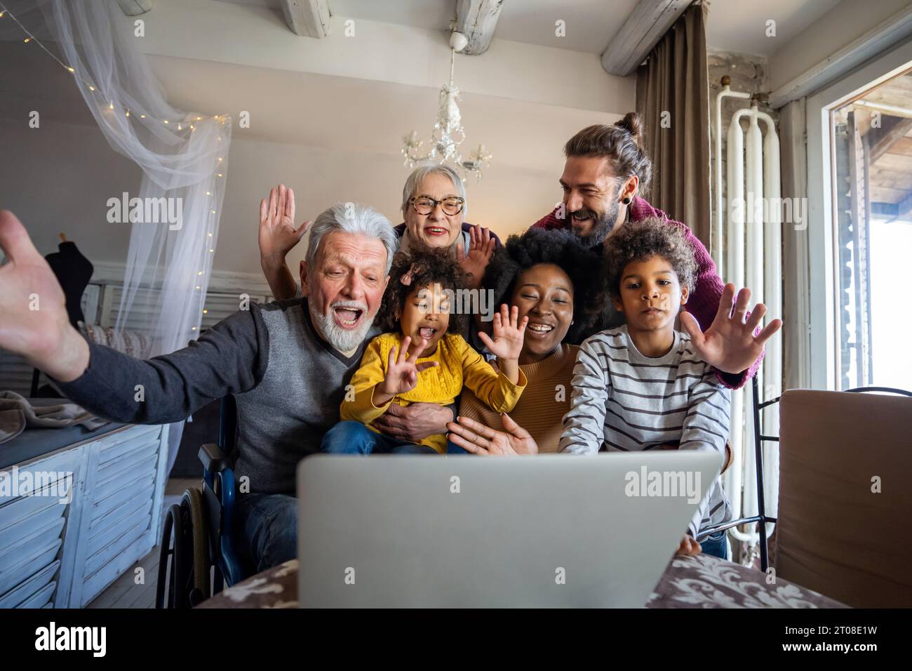 Extended multiethnic family together at home during video call. People ...