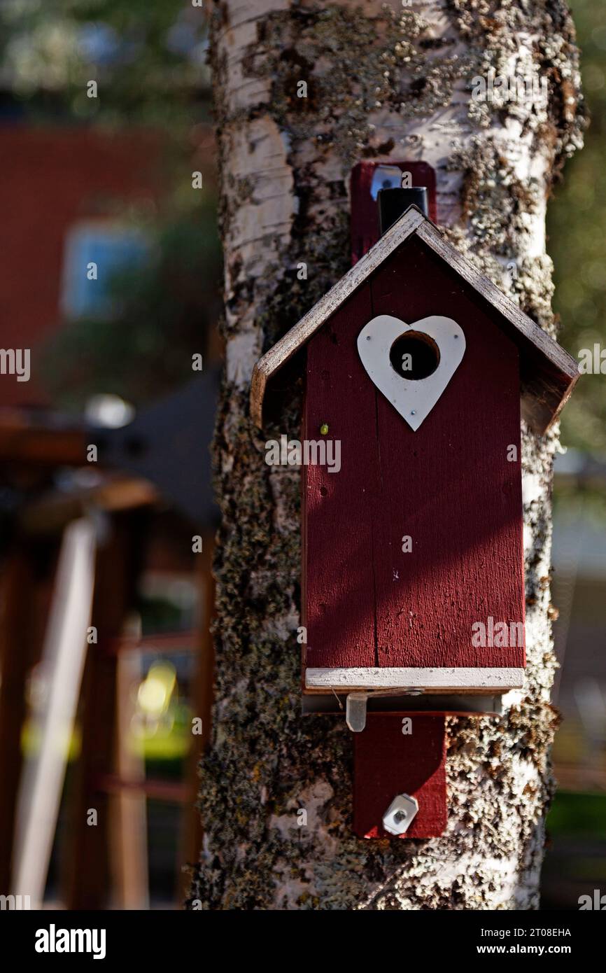 a red birdhouse with a white heart by the hole Stock Photo - Alamy