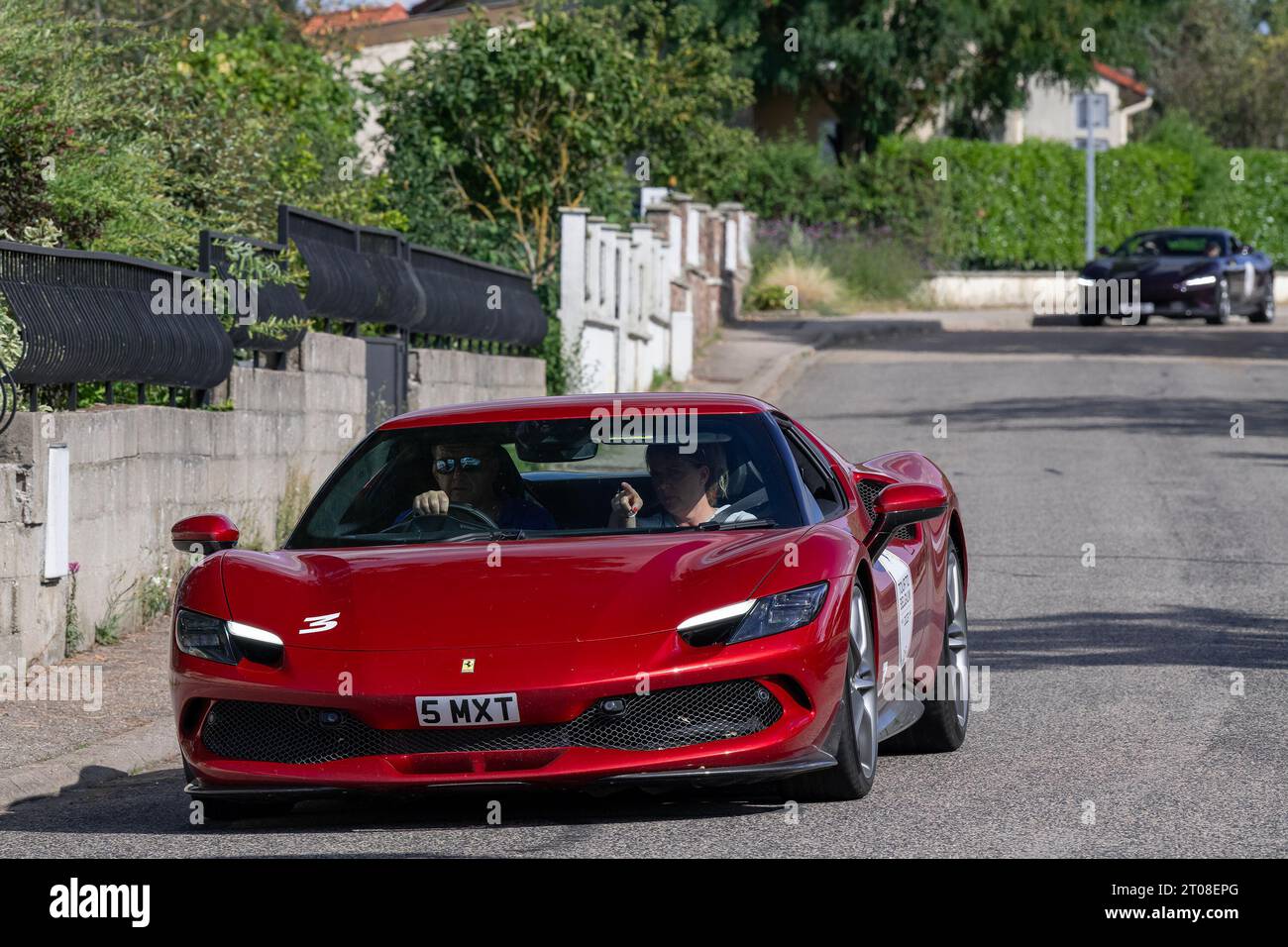 Red Ferrari 296 GTB driving on the road Stock Photo - Alamy