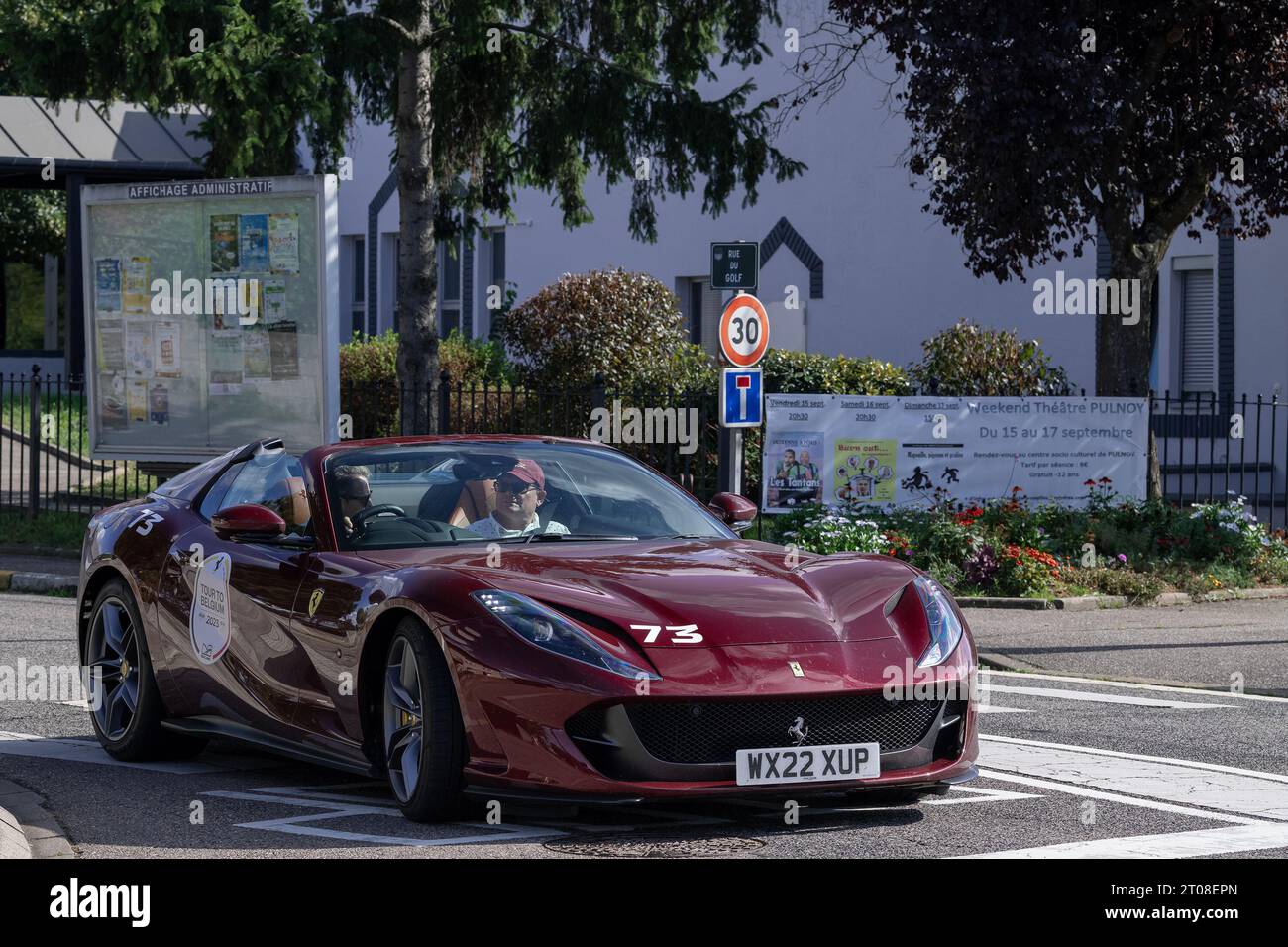 Burgundy Ferrari 812 GTS driving on the road Stock Photo - Alamy