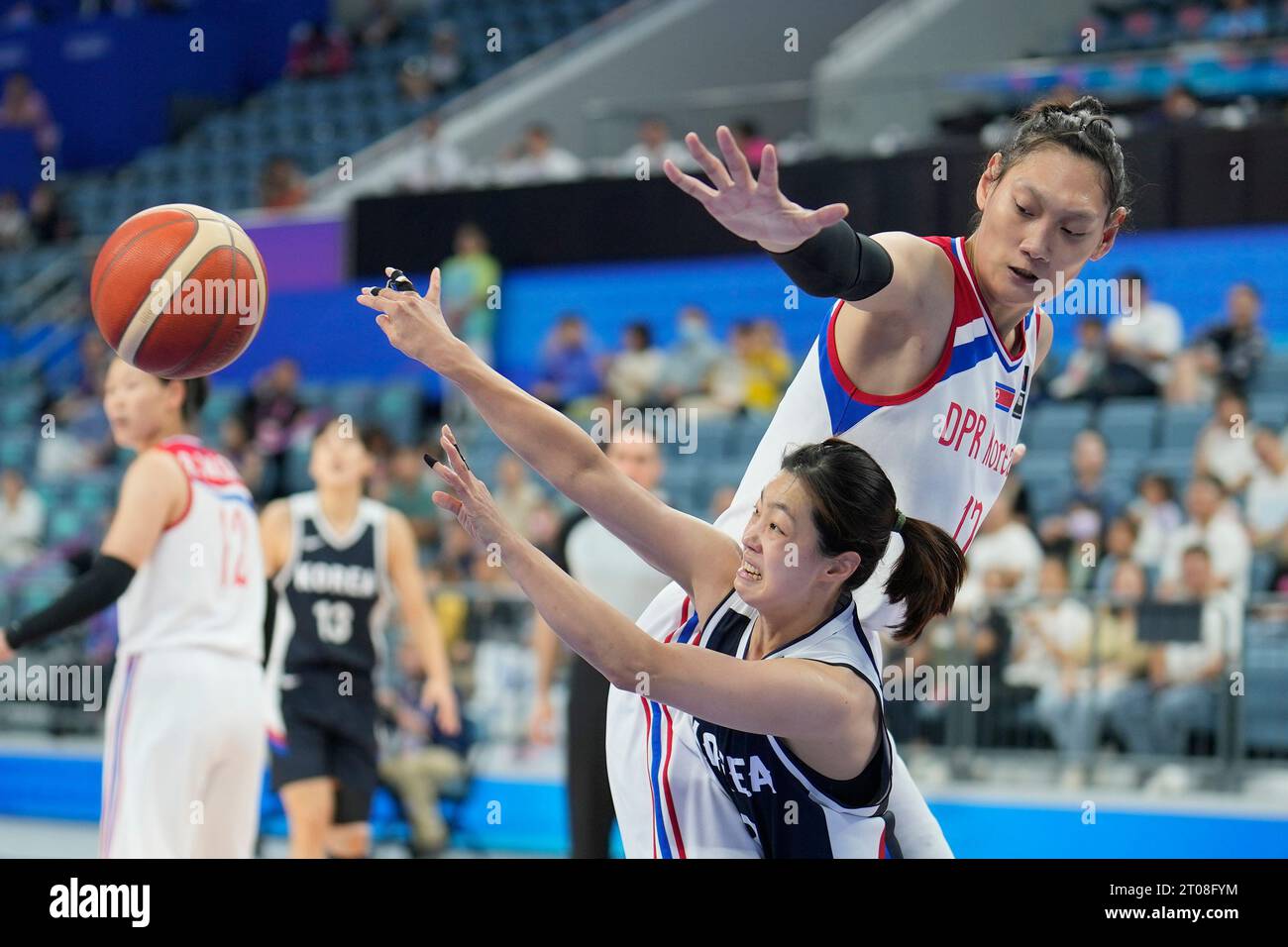 South Korea's guard Lee Kyung-eun (9), bottom, passes the ball around North Korea's center Pak ...