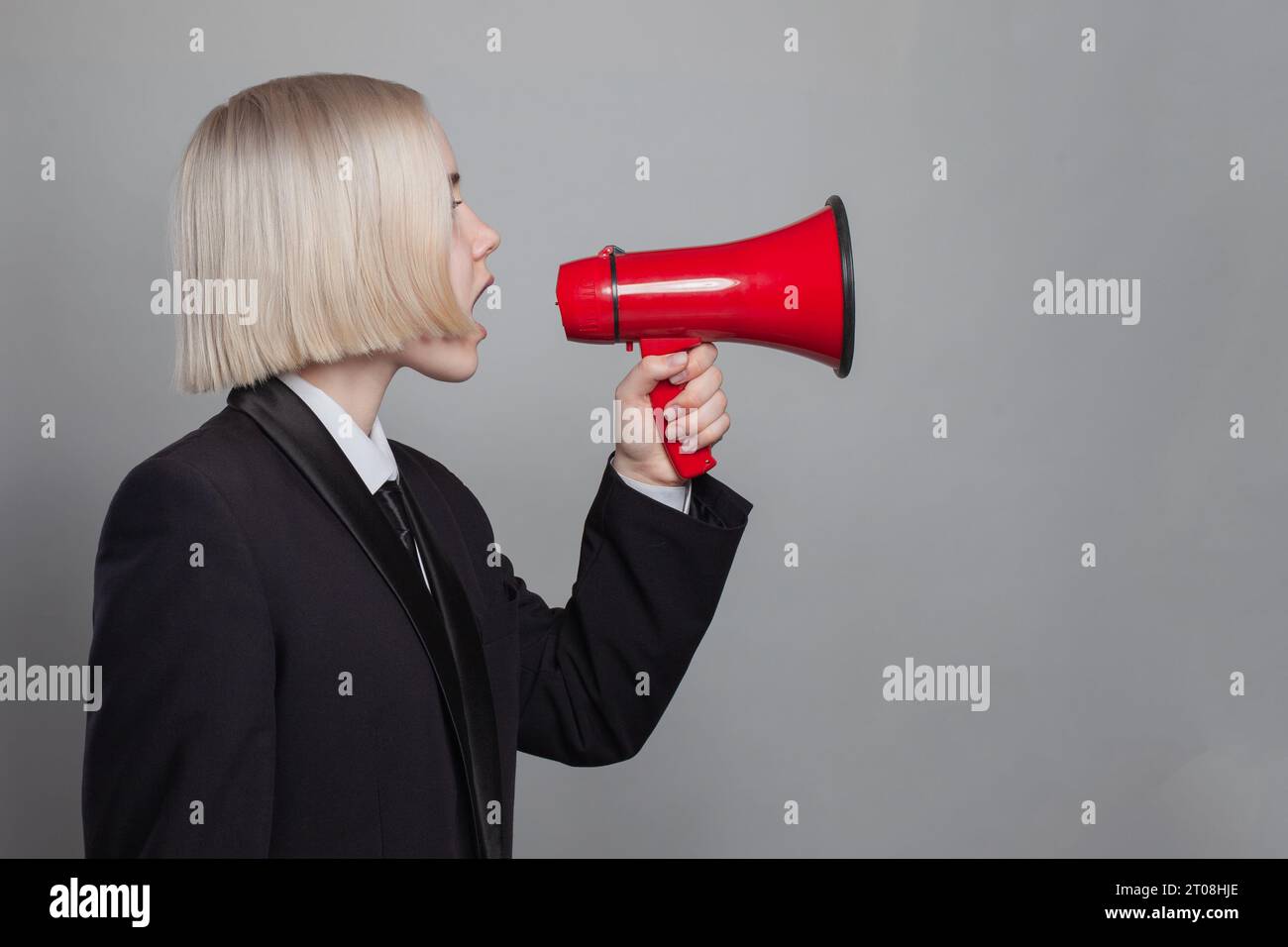 Young business woman holding megaphone loudspeaker shouting ...