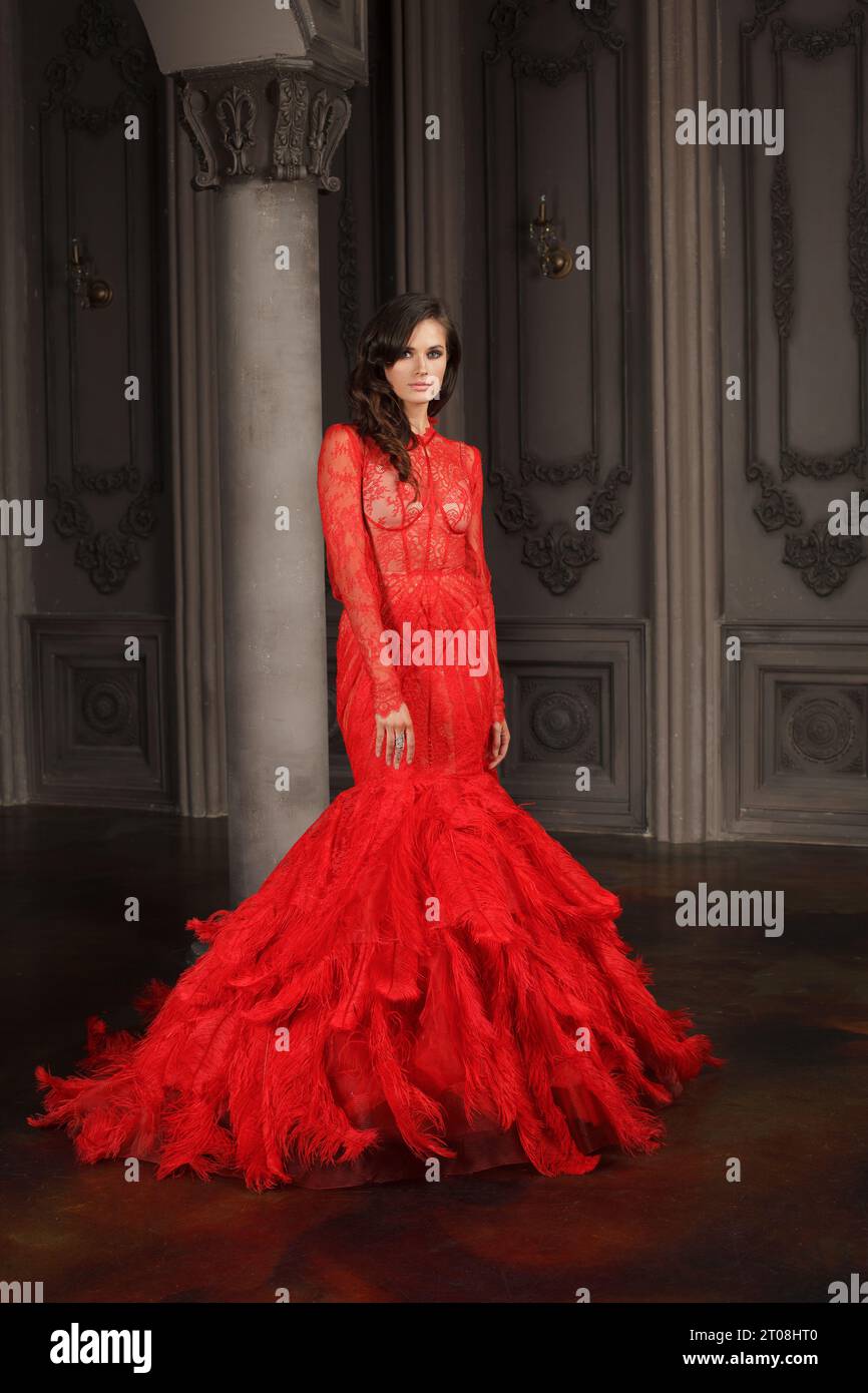 Gorgeous model woman wearing red dress posing in a luxurious palace ...