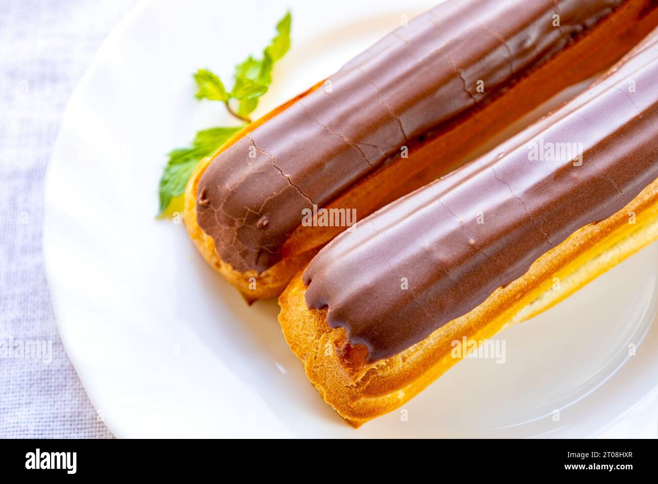 French pastry eclairs with cream filling covered with melted milk ...