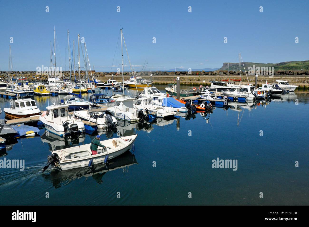 A boatman and his dog sailing out of Ballycastle marina in County ...