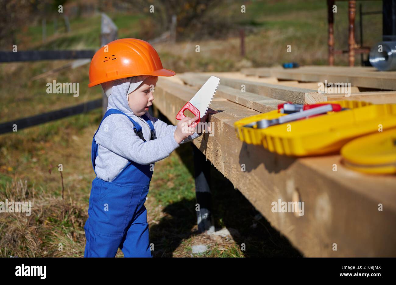 Boy toddler playing as builder on construction site. Child carpenter in ...