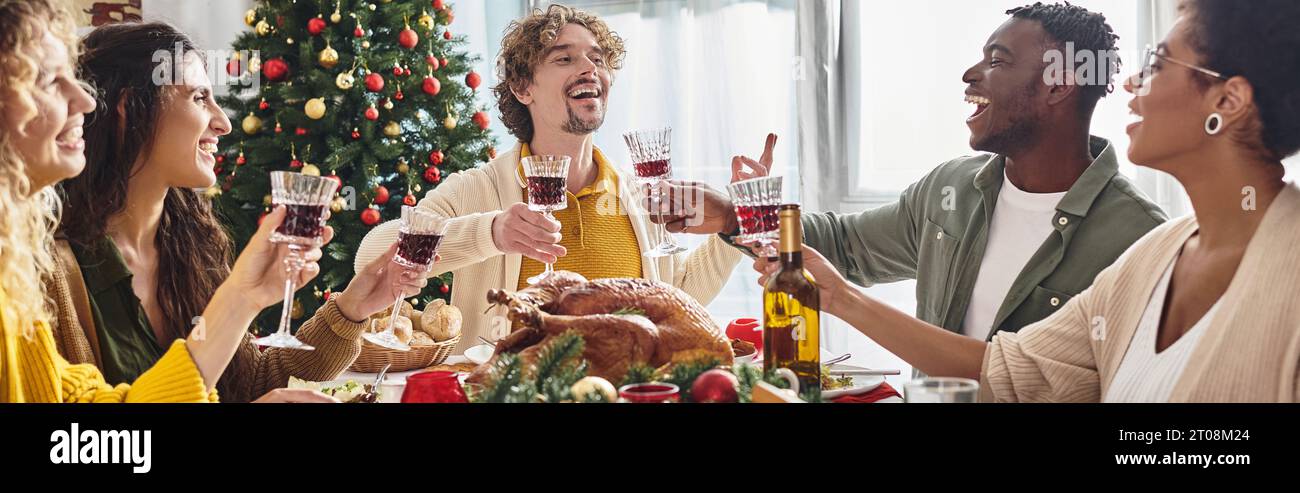 multicultural family gesturing and laughing sitting at festive table ...