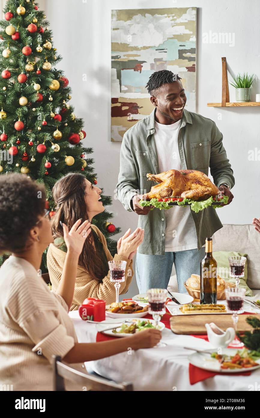 big multicultural family gesturing and laughing and one holding plate ...