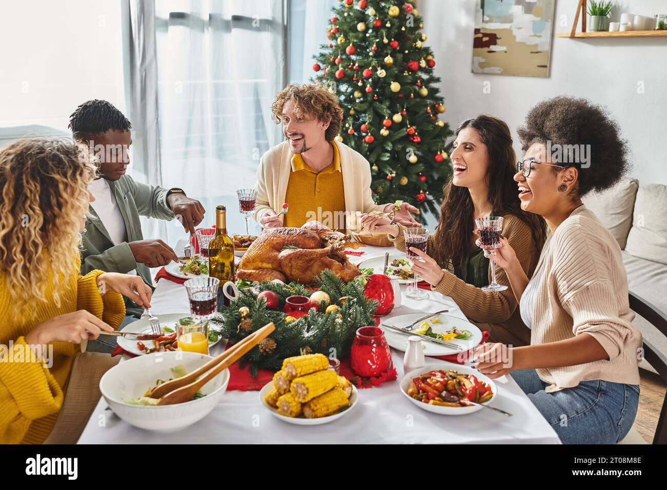 big multicultural family having festive lunch and talking lively with ...