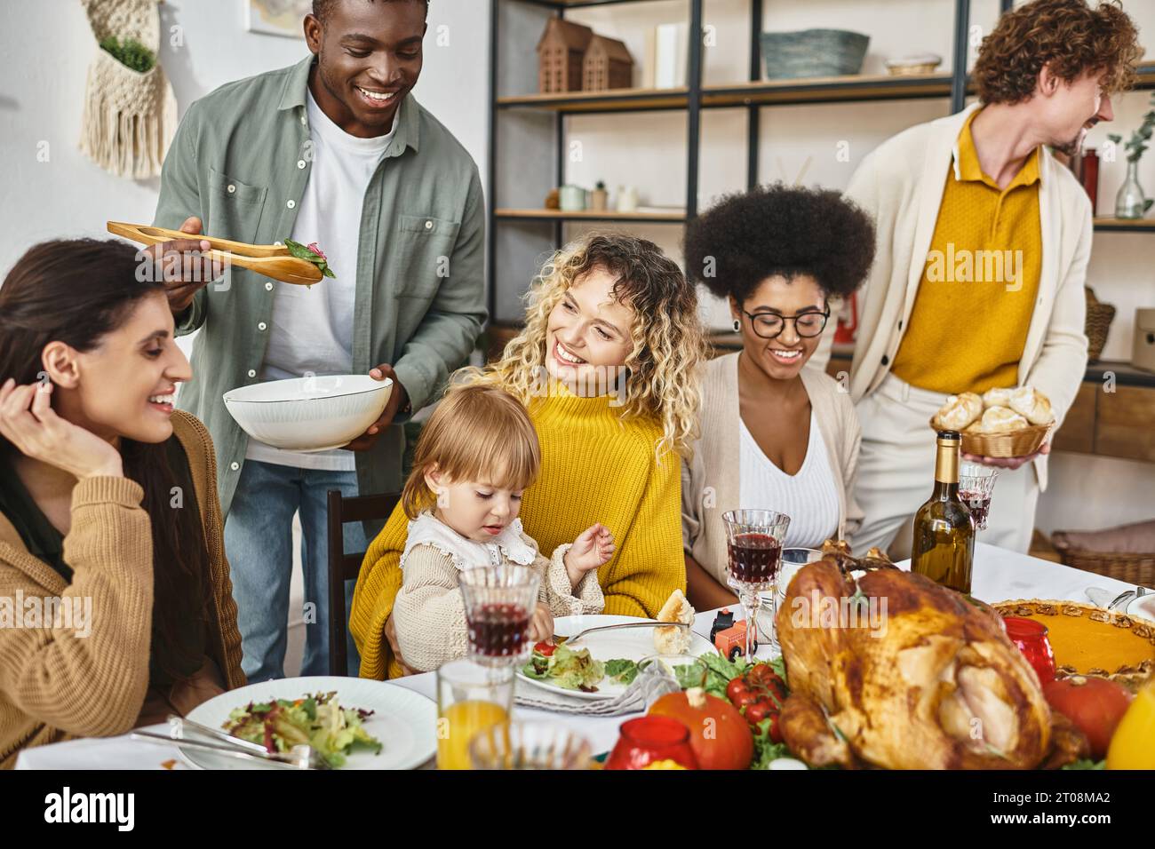 Thanksgiving feast, positive multiethnic friends and family gathering ...