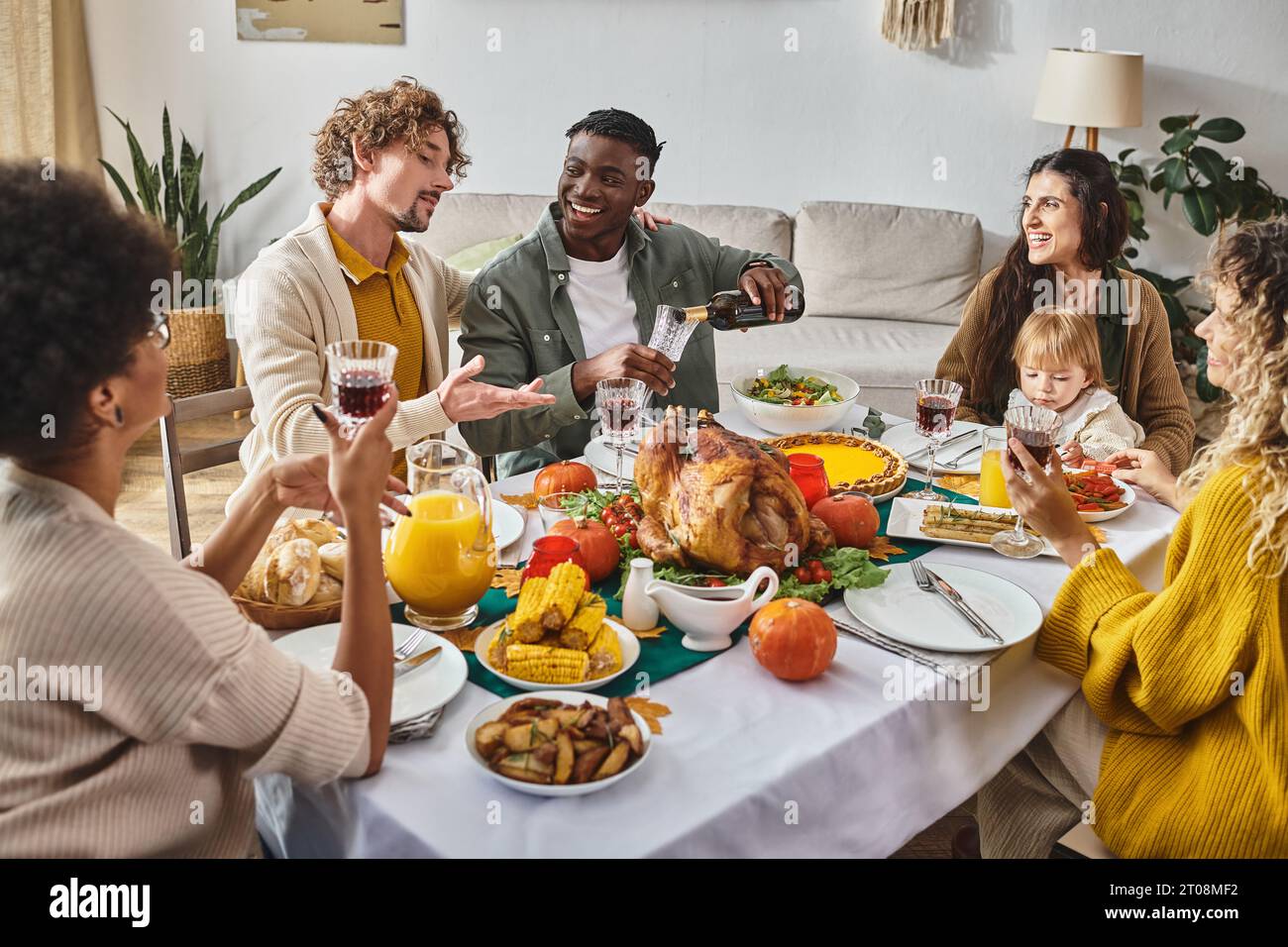 multicultural family enjoying Thanksgiving meal at festive table ...