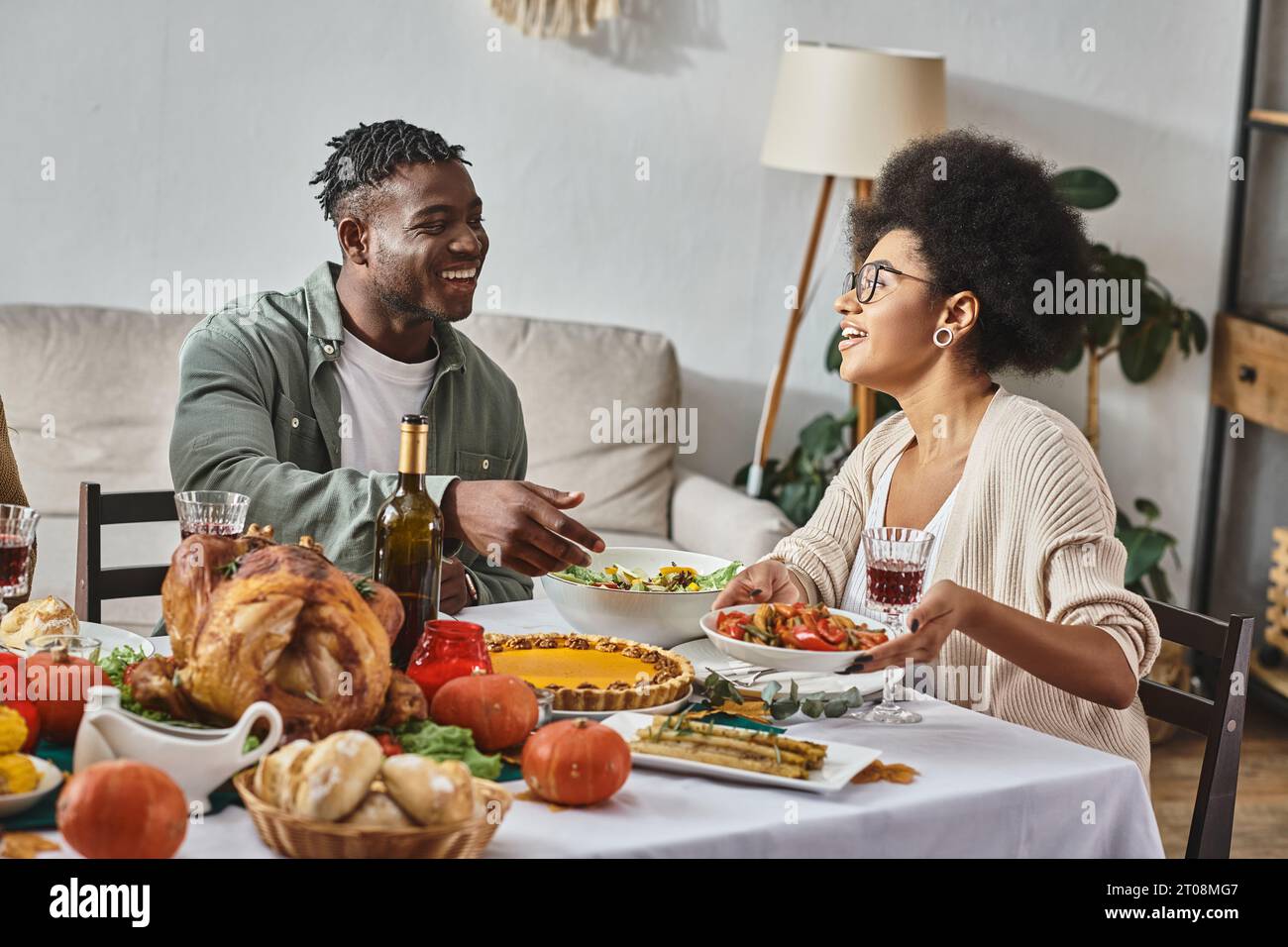 happy african american woman passing plate with cooked meal to relative ...
