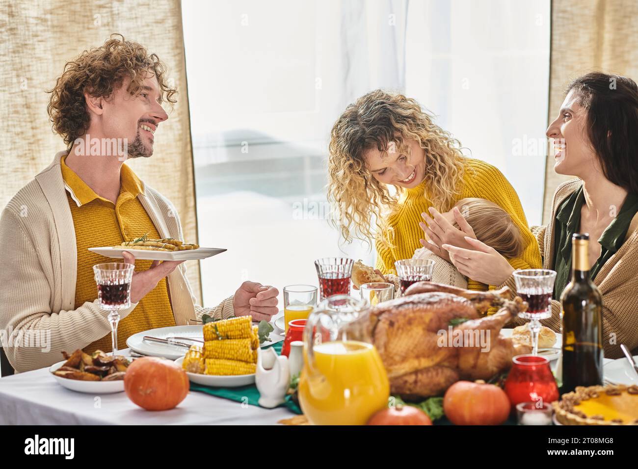 happy multiracial family enjoying delicious dinner while gathering on ...