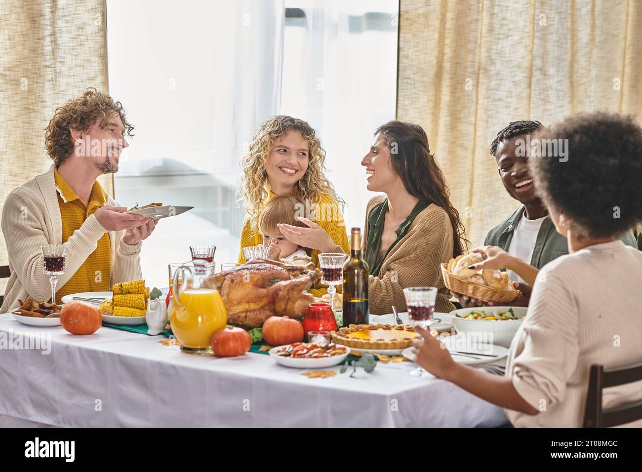 happy multiracial family and friends enjoying meals and drinks while ...