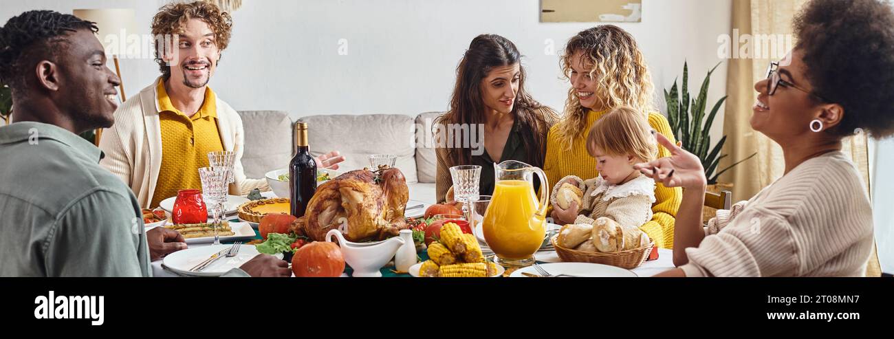 happy multiracial family and friends talking and smiling during ...