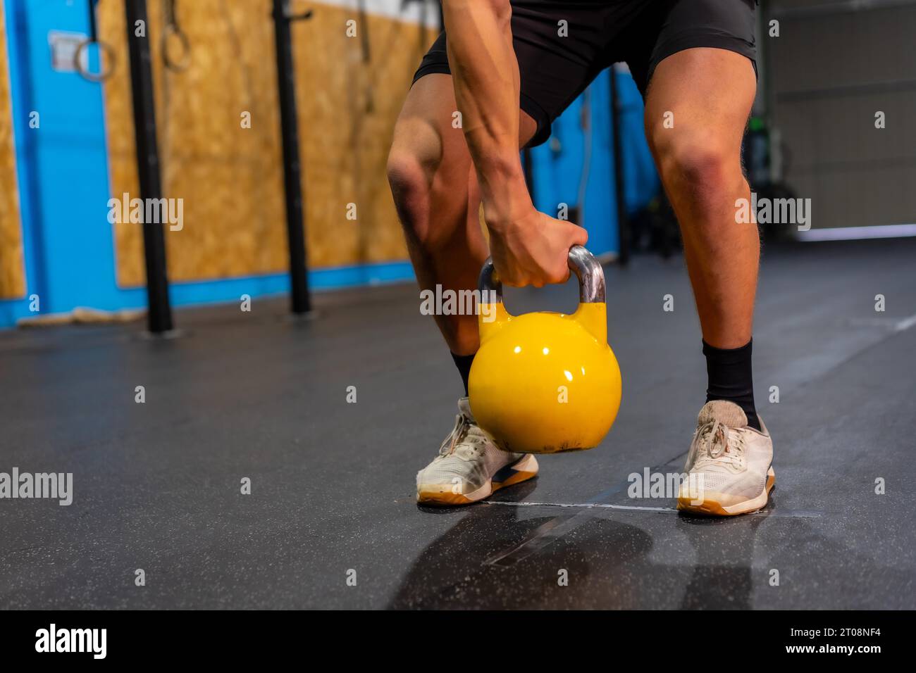 Legs of a disabled man exercising with a kettlebell in a cross training ...
