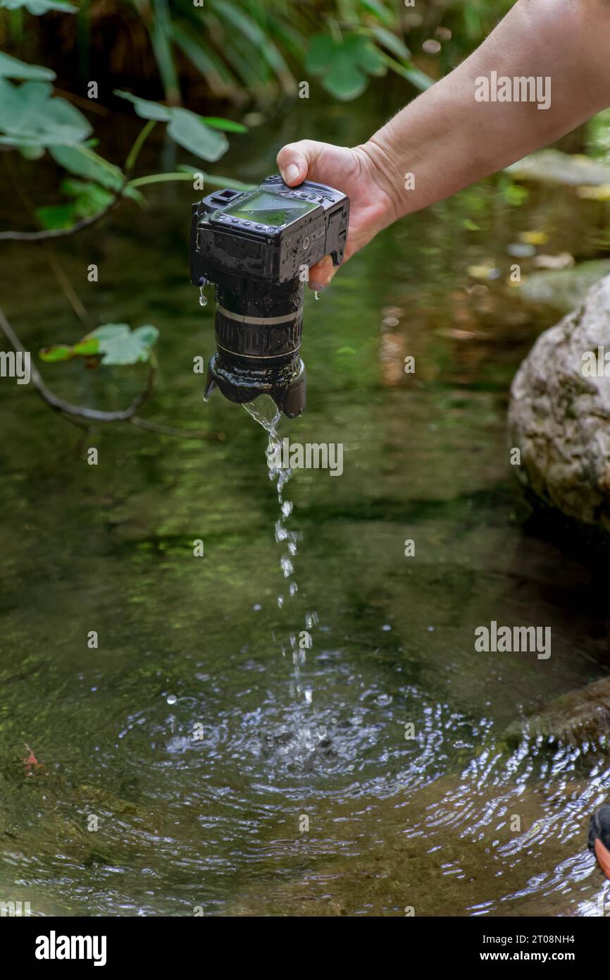 A reflex camera accidentally falls into the river, a man pulls it out ...