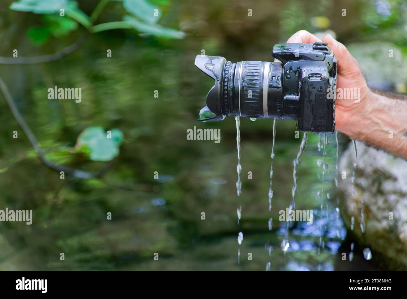 A reflex camera accidentally falls into the river, a man pulls it out ...
