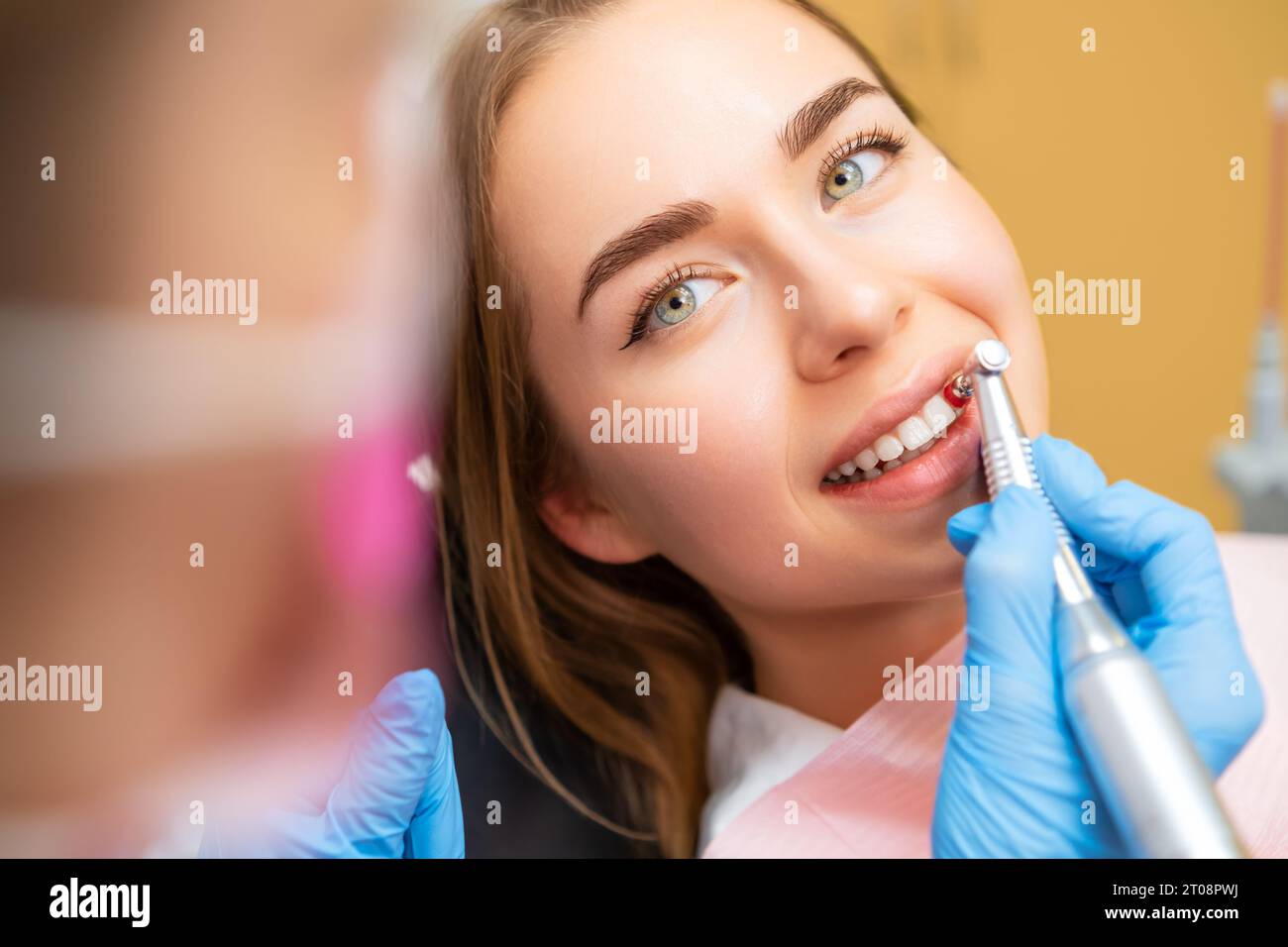 Dentist performing teeth grinding procedure in dental clinic. Woman ...