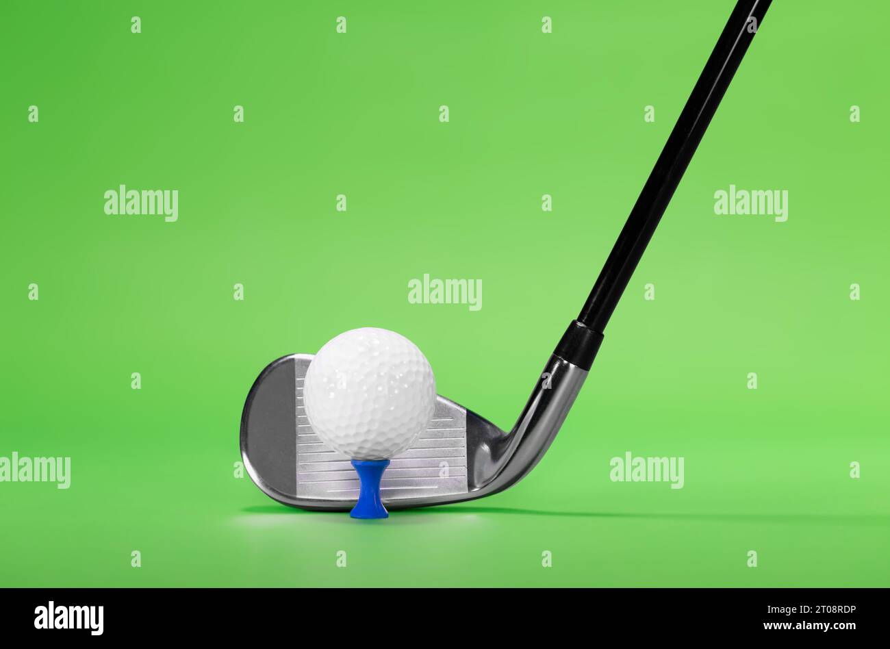Golf Club Iron with Ball on a Blue Tee, photographed on a Green ...