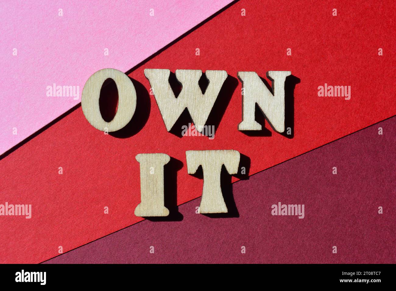 Own It, words in wooden alphabet letters isolated on red and pink ...