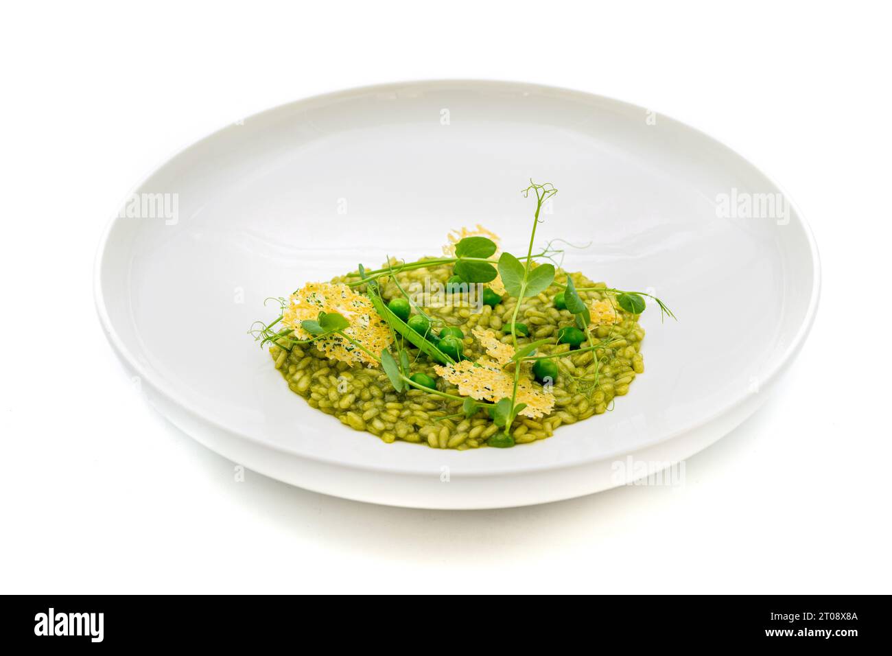 Risotto with peas on a white porcelain plate on an isolated white ...