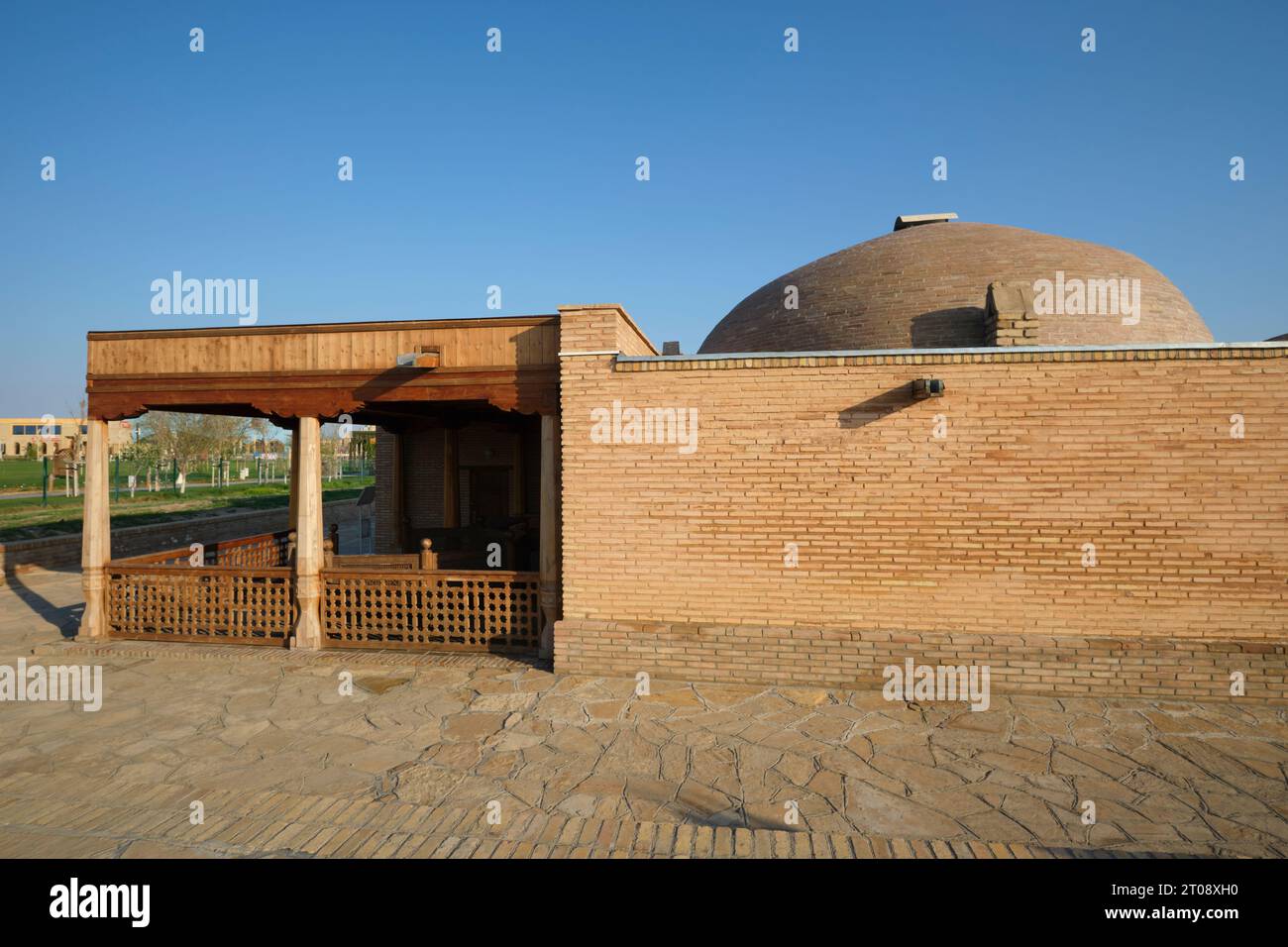 Exterior view of the modest, tan brick building facade with entry porch ...