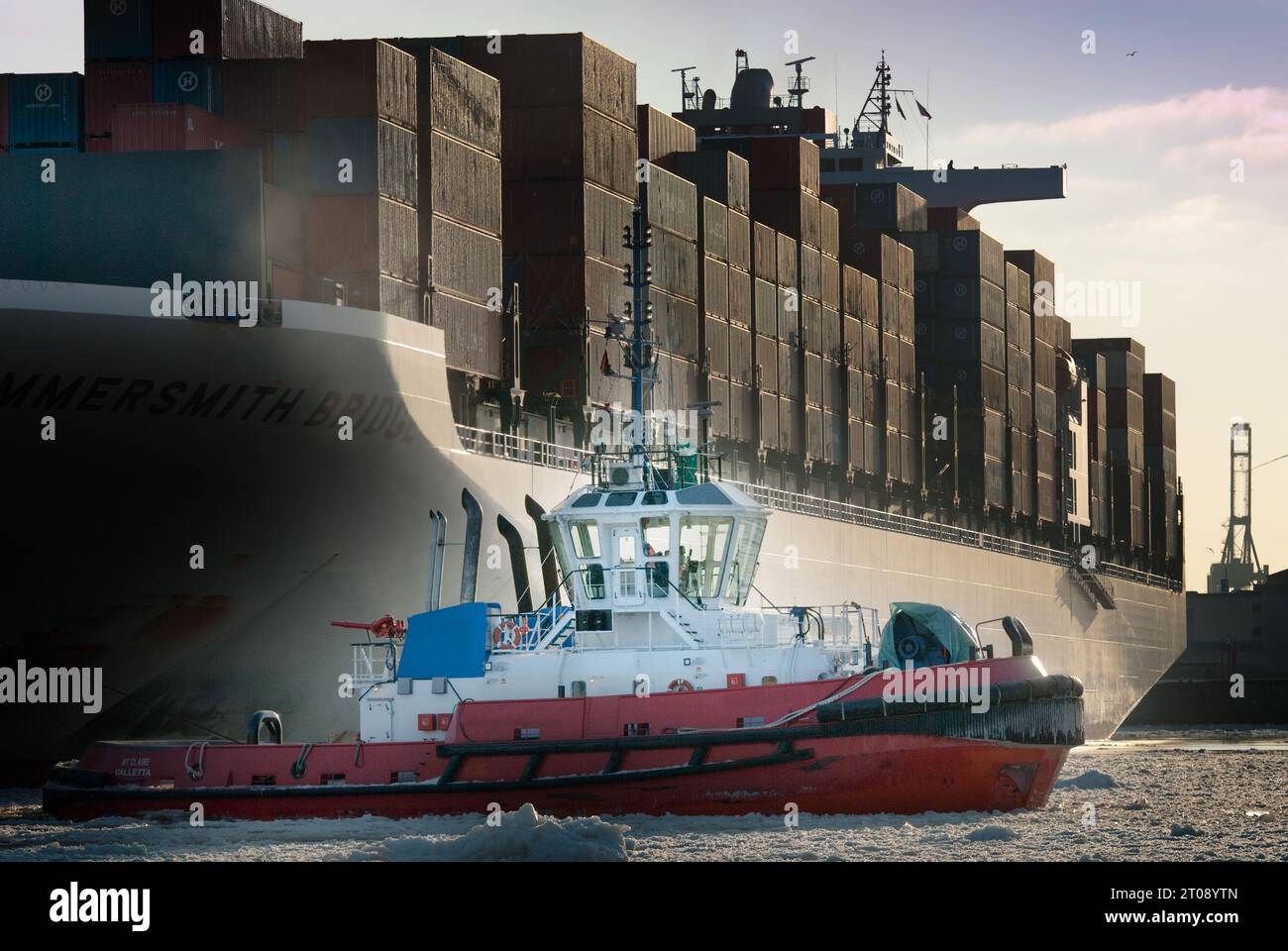 Port tug maneuvers the 336-meter-long container ship “Hammersmith ...