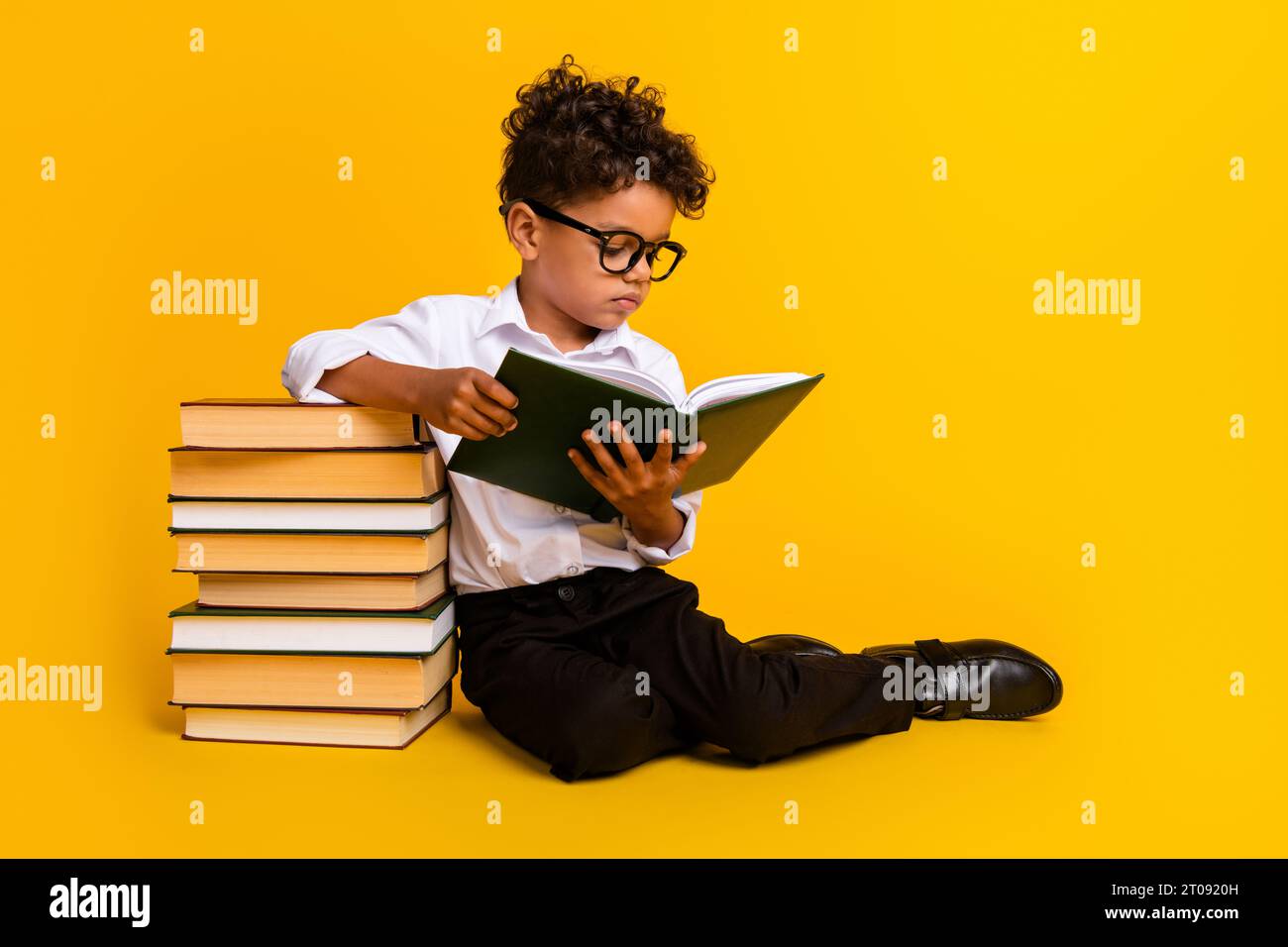 Full size portrait of clever diligent schoolkid sit floor read pile ...