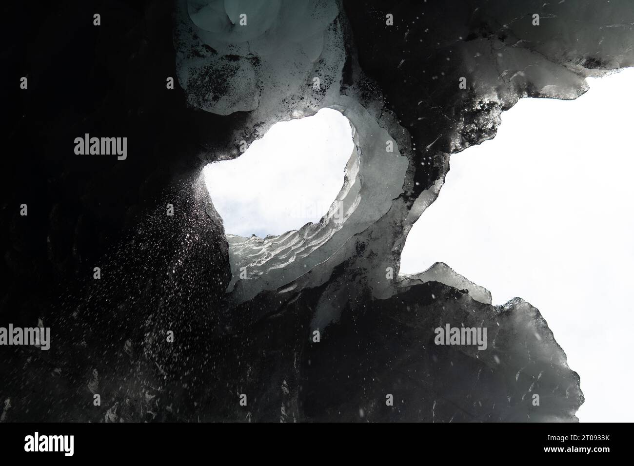 Water droplets dropping from a glacier from the inside of an ice cave ...