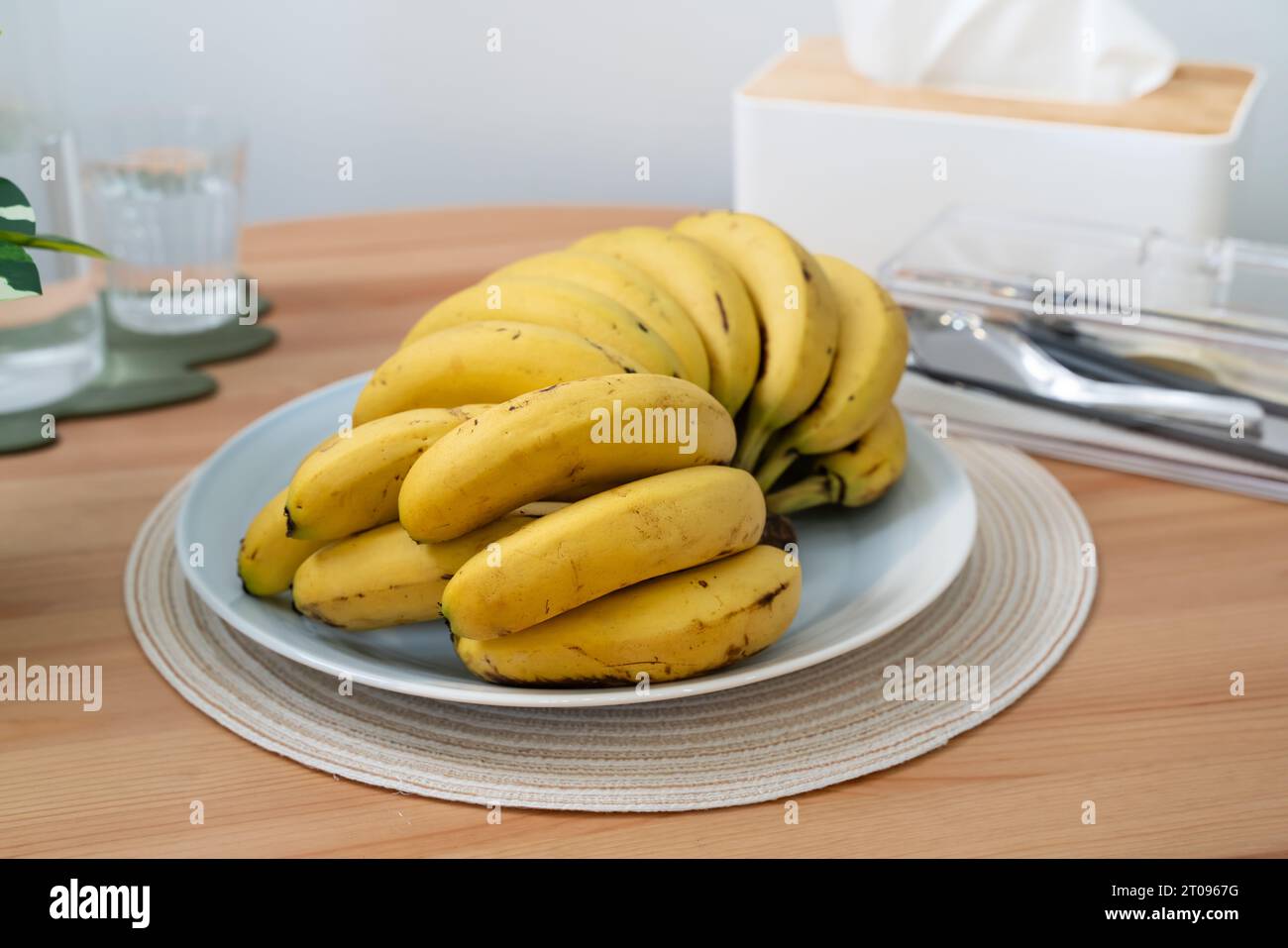 A bunch of fresh banana lie on the dining table in a modern kitchen ...