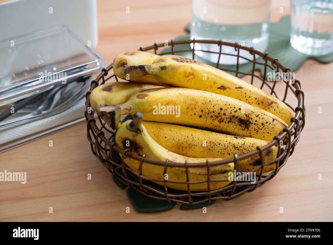 A bunch of fresh banana lie on the dining table in a modern kitchen ...