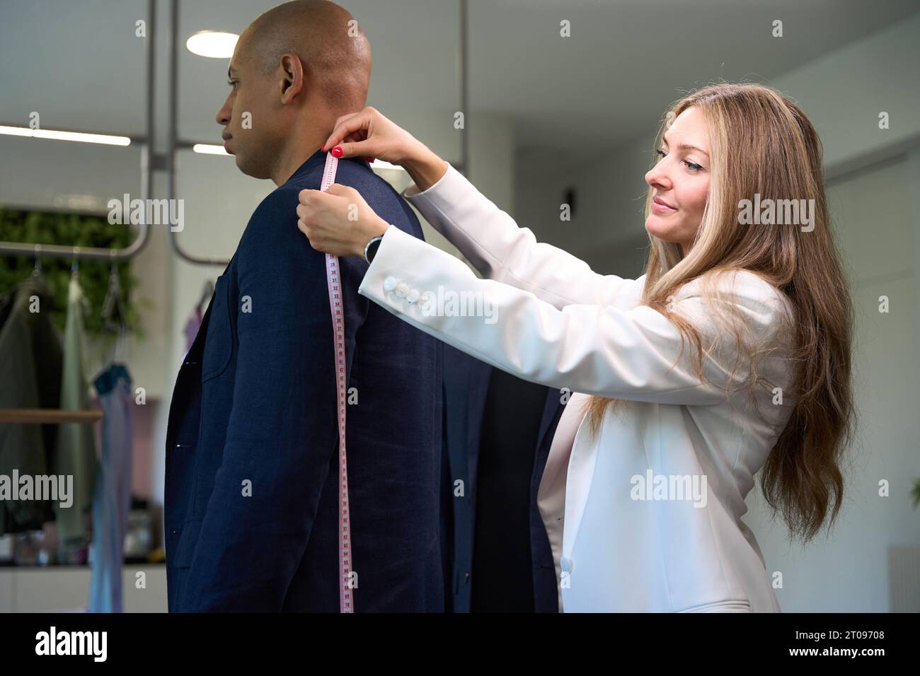 Concentrated seamstress taking man measurements for sewing Stock Photo ...